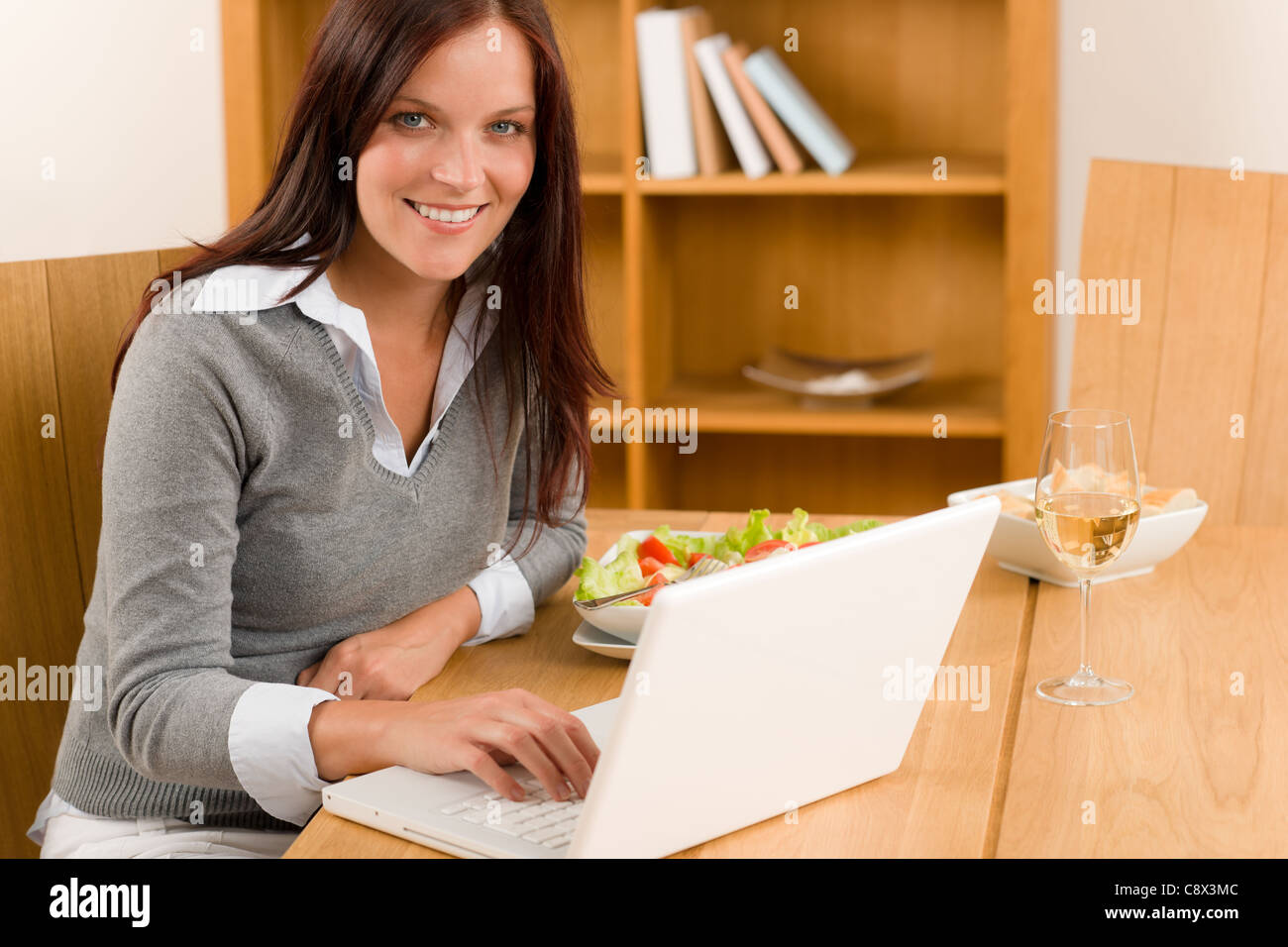 Working lunch at home attractive woman with laptop eat salad Stock ...
