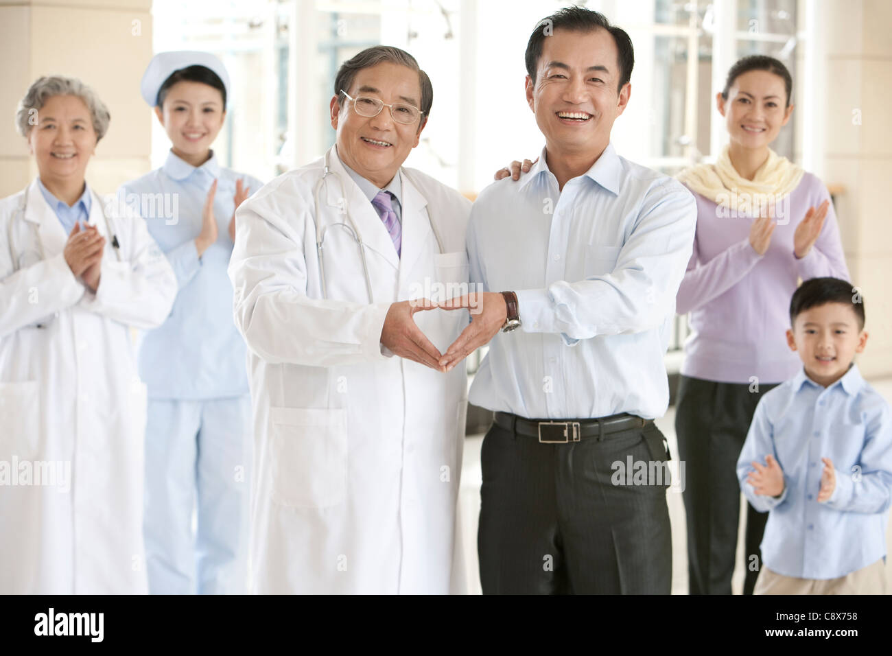 Father Makes a Heart Shape With Hands With Senior Doctor Stock Photo ...