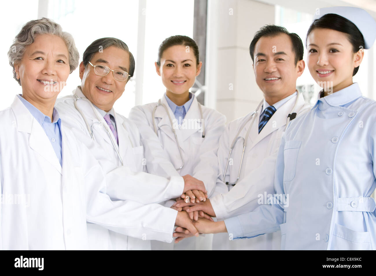 Doctors and Nurse Hands in a Huddle Stock Photo - Alamy