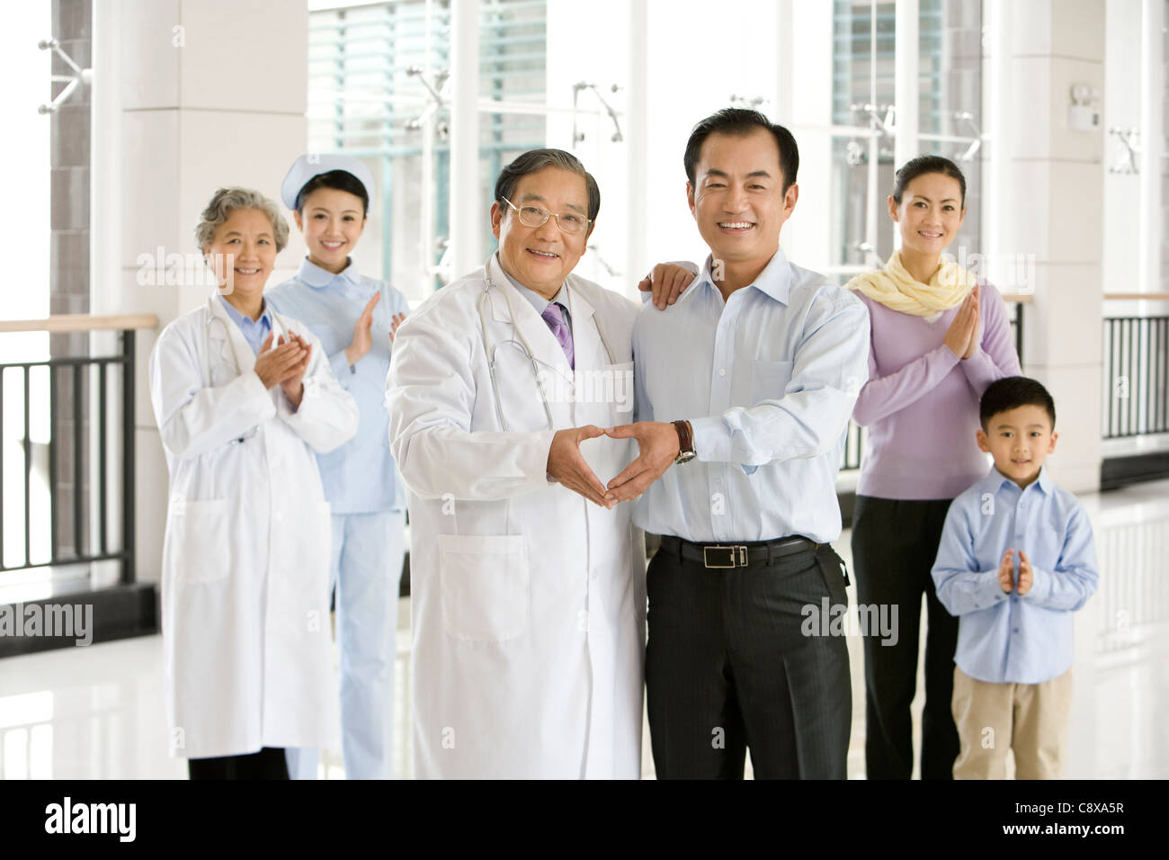 Father Makes a Heart Shape With Hands With Senior Doctor Stock Photo ...