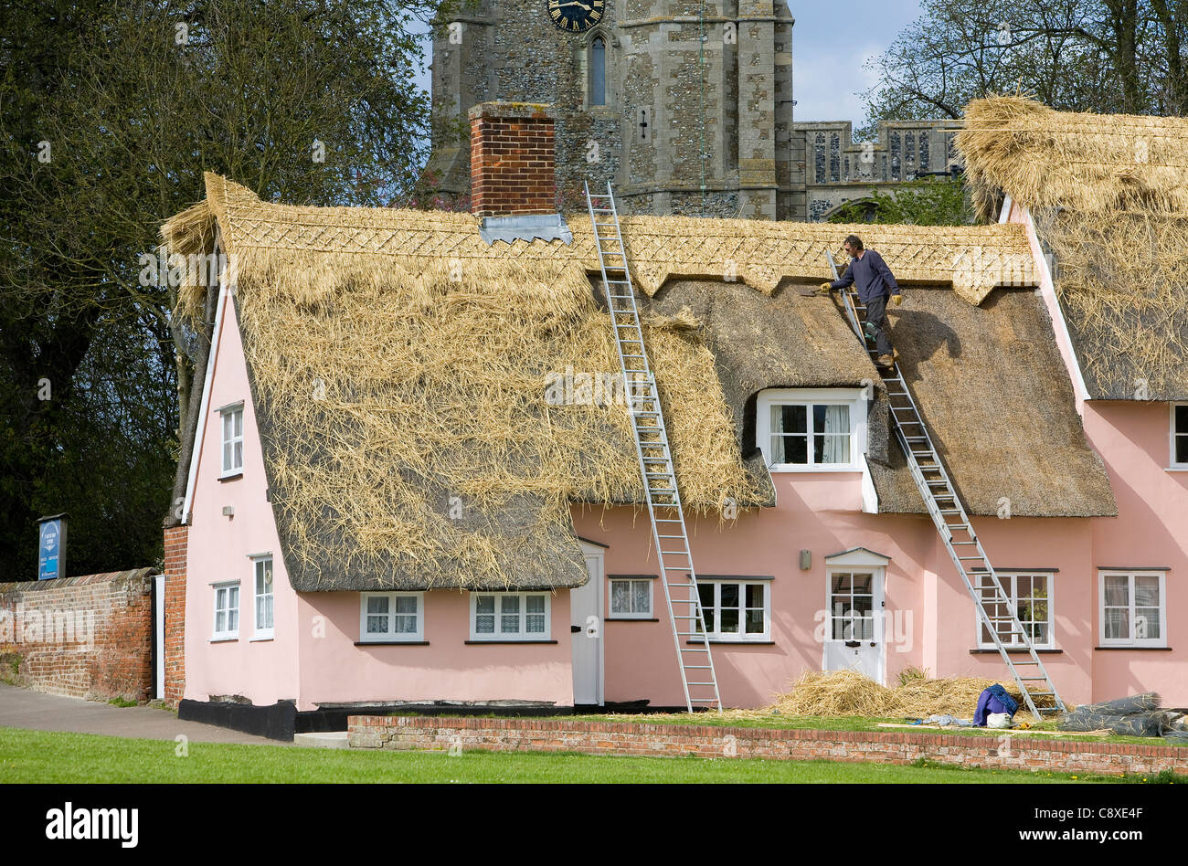 Thatcher working on thatched cottage roof in Cavendish, Suffolk UK ...