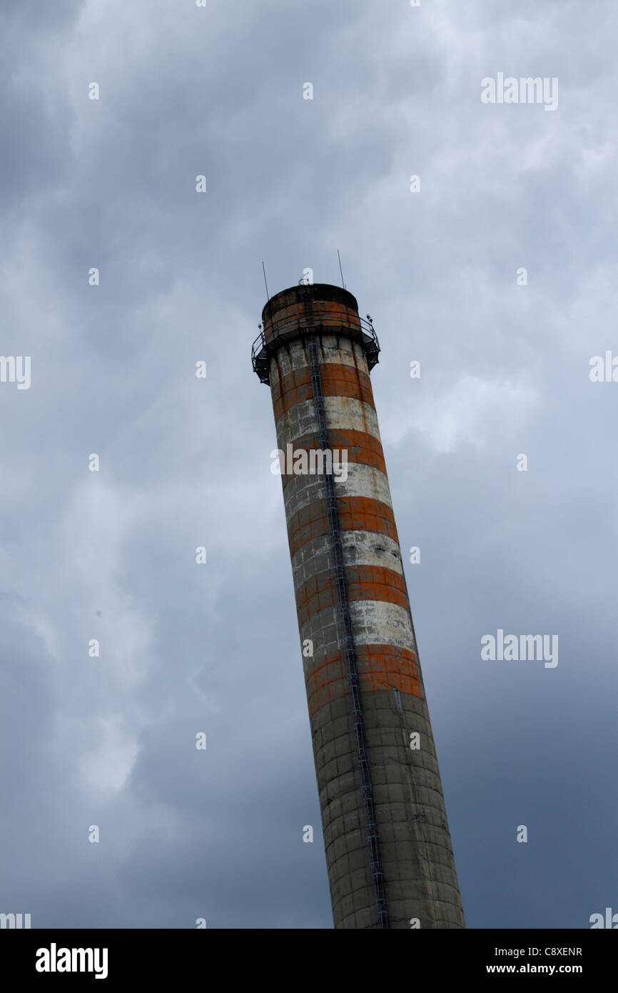 Industrial smoke stack painted red and white with a dramatic sky in ...