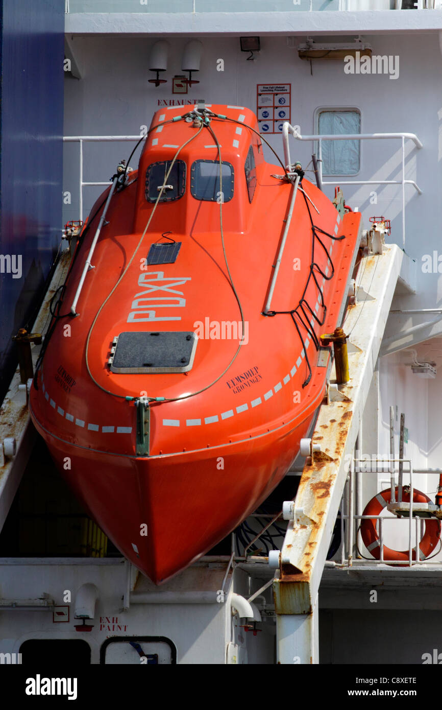 Bright orange, totally enclosed free-fall rescue boat on a freight ship ...