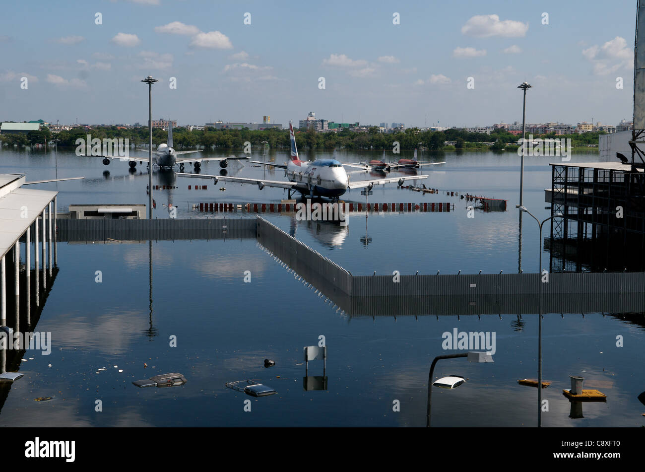 Airplanes on flooded runway, cars flooded in foreground. Don Muang ...