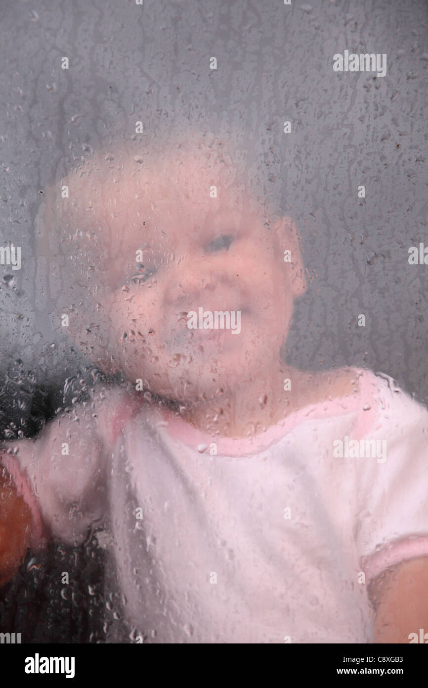 Adorable toddler watching the rain drops at the window Stock Photo - Alamy