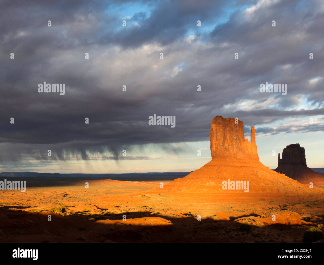 Virga (rain) falls by the Mittens at sunset, Monument Valley Tribal ...