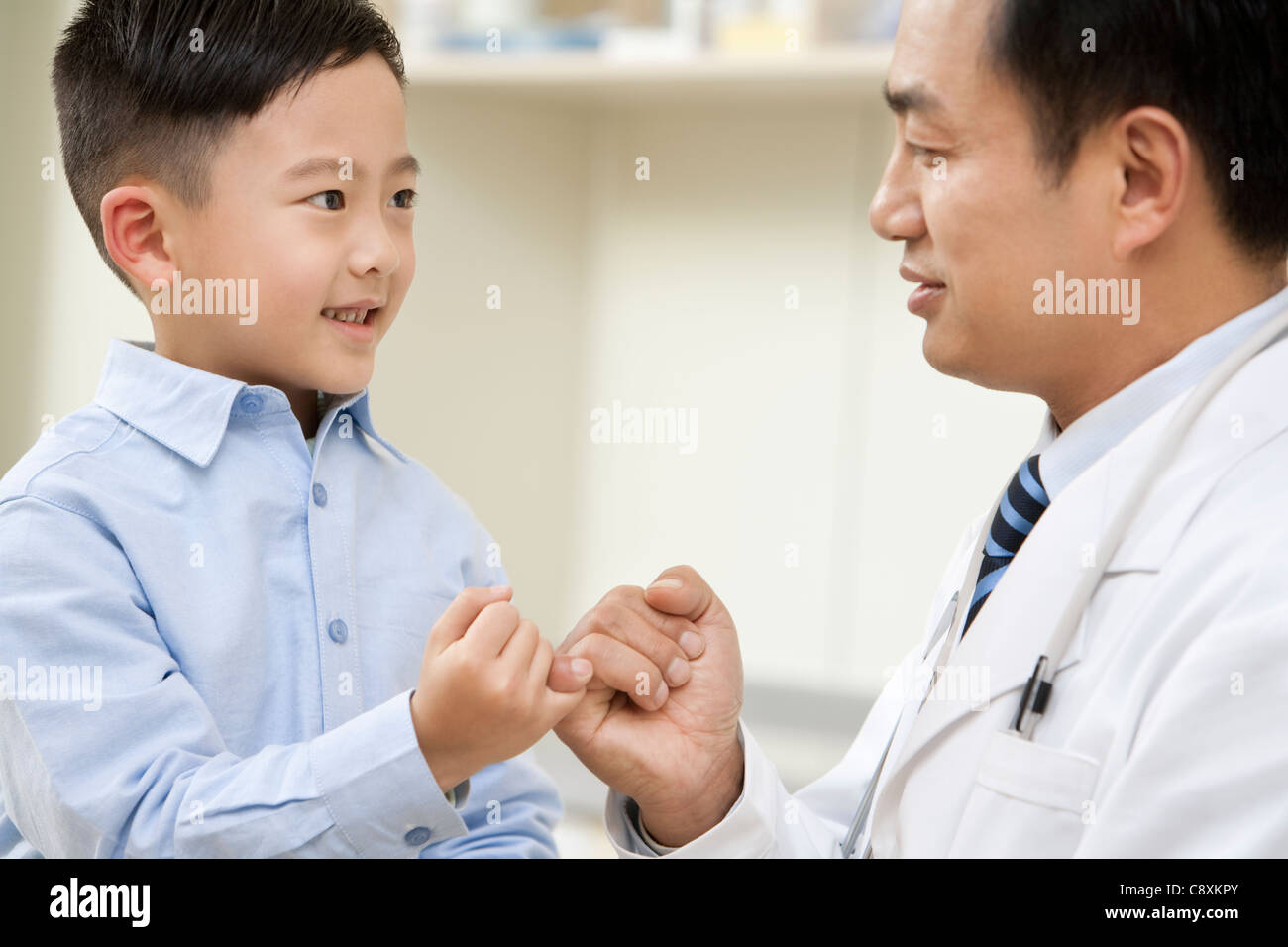 Young Boy and Doctor Pinky Promise Stock Photo - Alamy