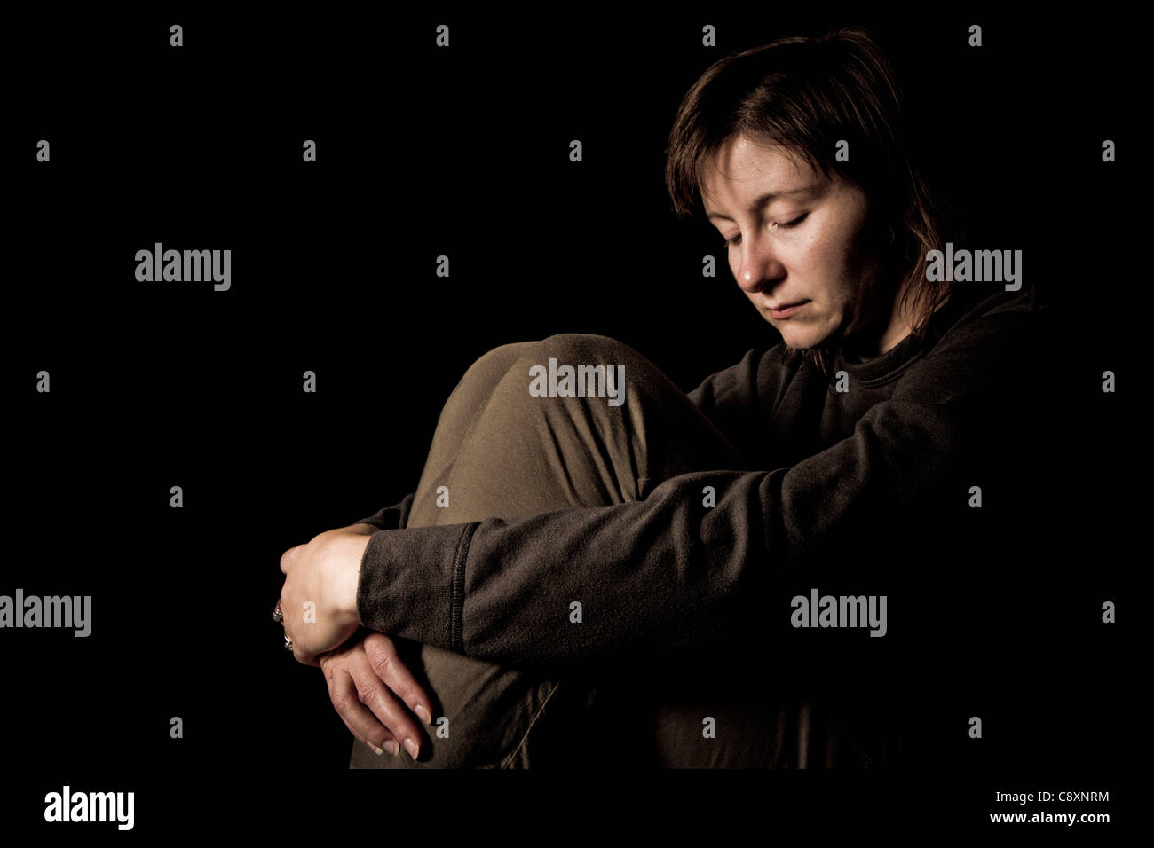 Depressed woman sitting alone Stock Photo - Alamy