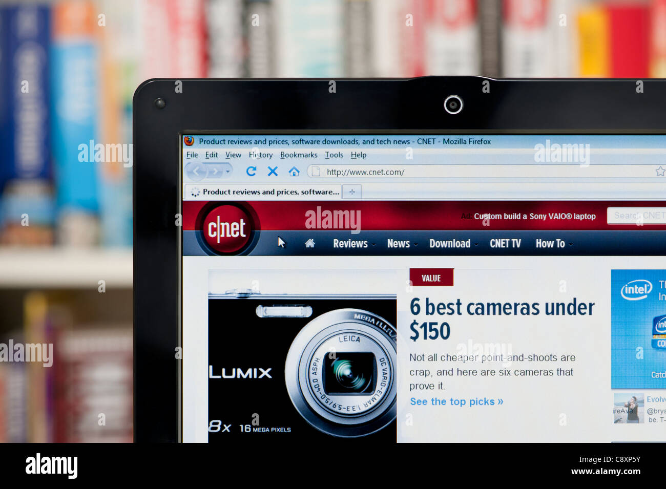 The CNET website shot against a bookcase background (Editorial use only ...