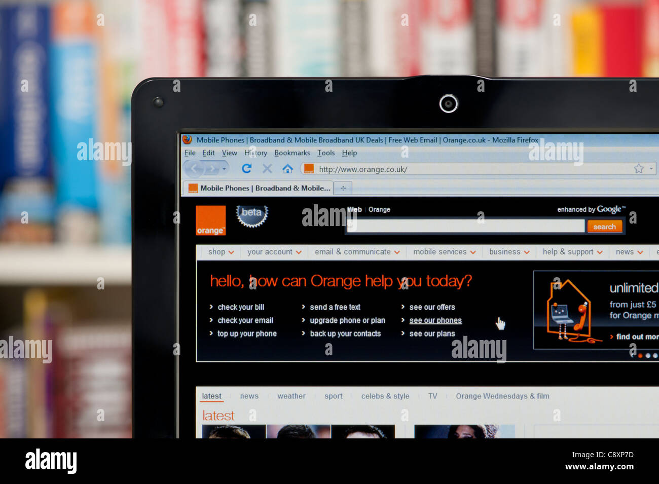 The Orange website shot against a bookcase background (Editorial use ...