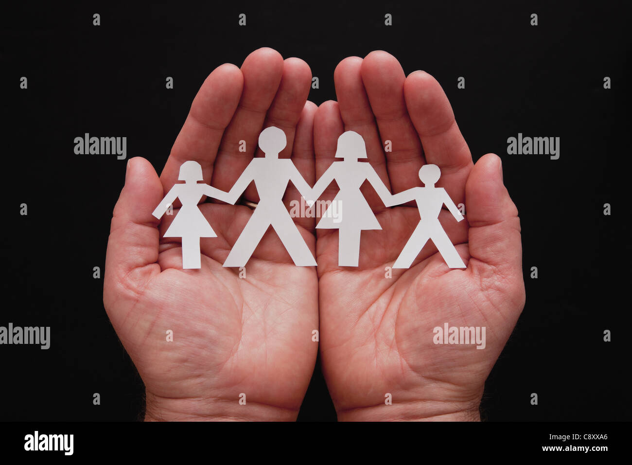 Studio shot of hands holding papercut family Stock Photo - Alamy