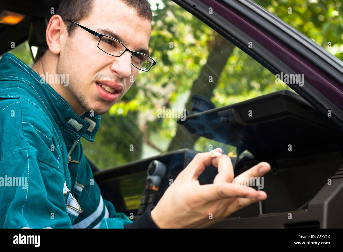 Young worker smoking in the car Stock Photo - Alamy