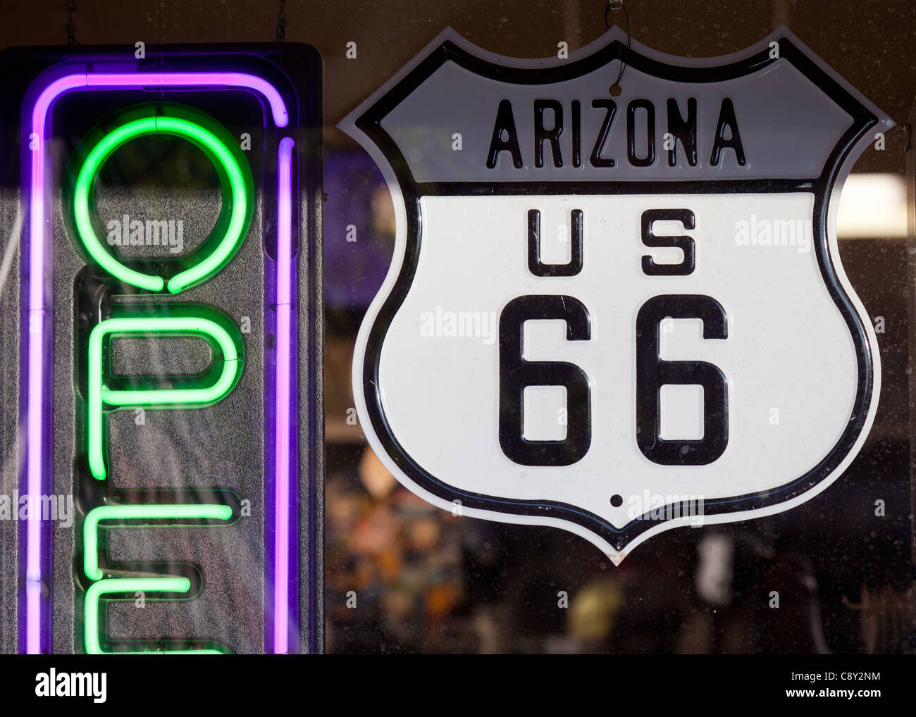 A white route 66 shield next to an Open neon sign in a tourist shop ...