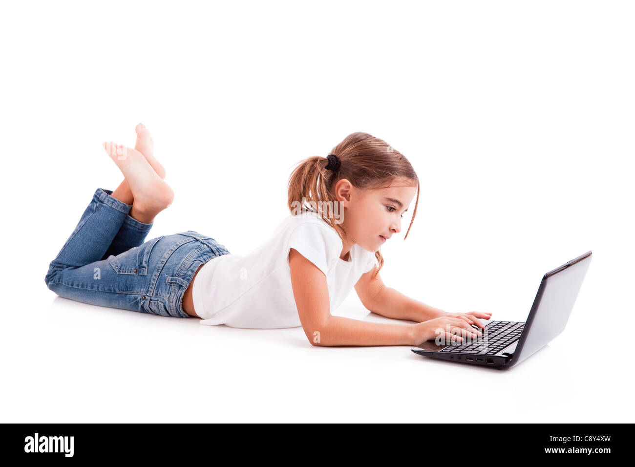 Little girl lying on floor working with a laptop Stock Photo - Alamy