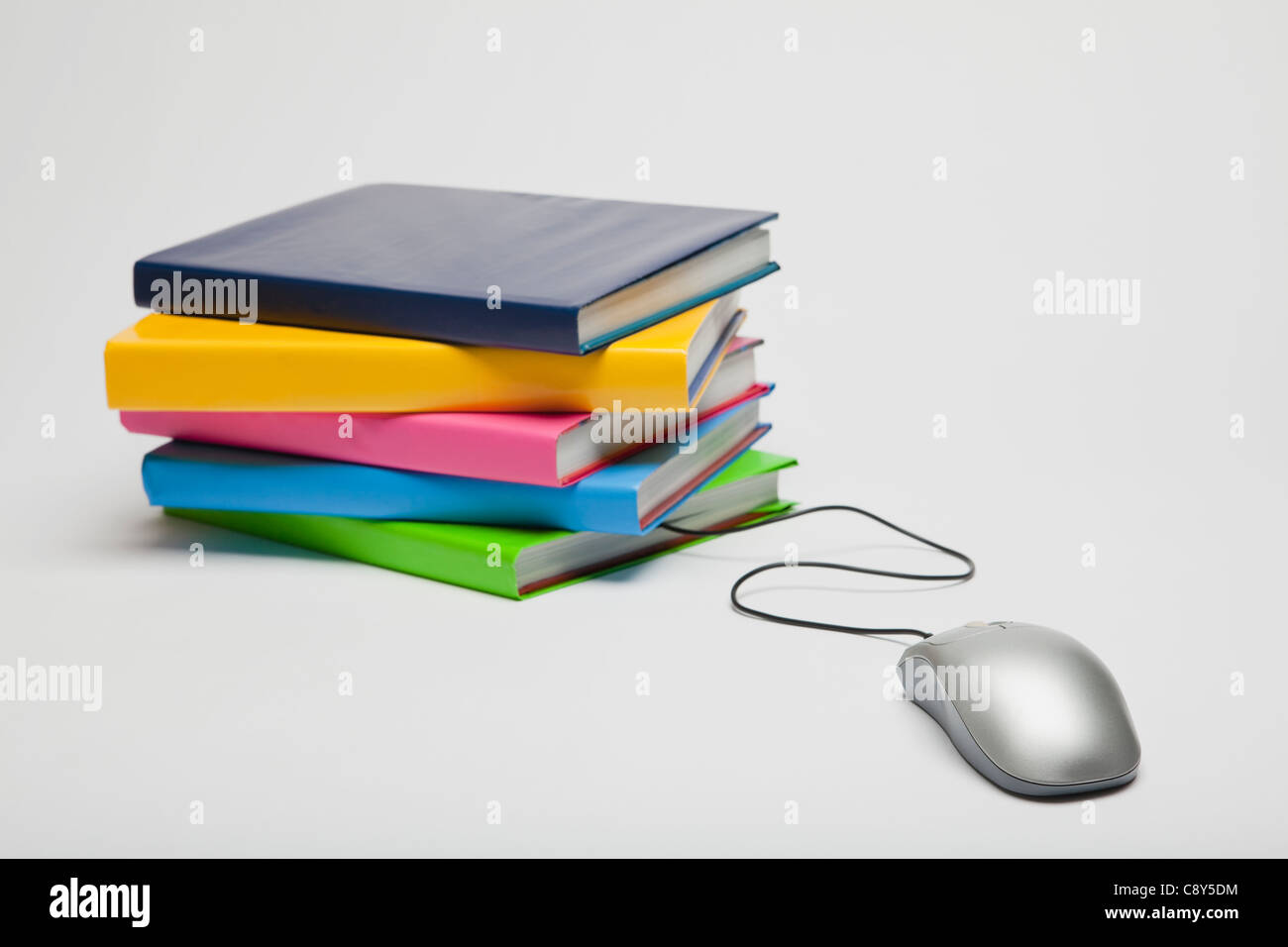 Stack of colorful books and computer mouse Stock Photo - Alamy