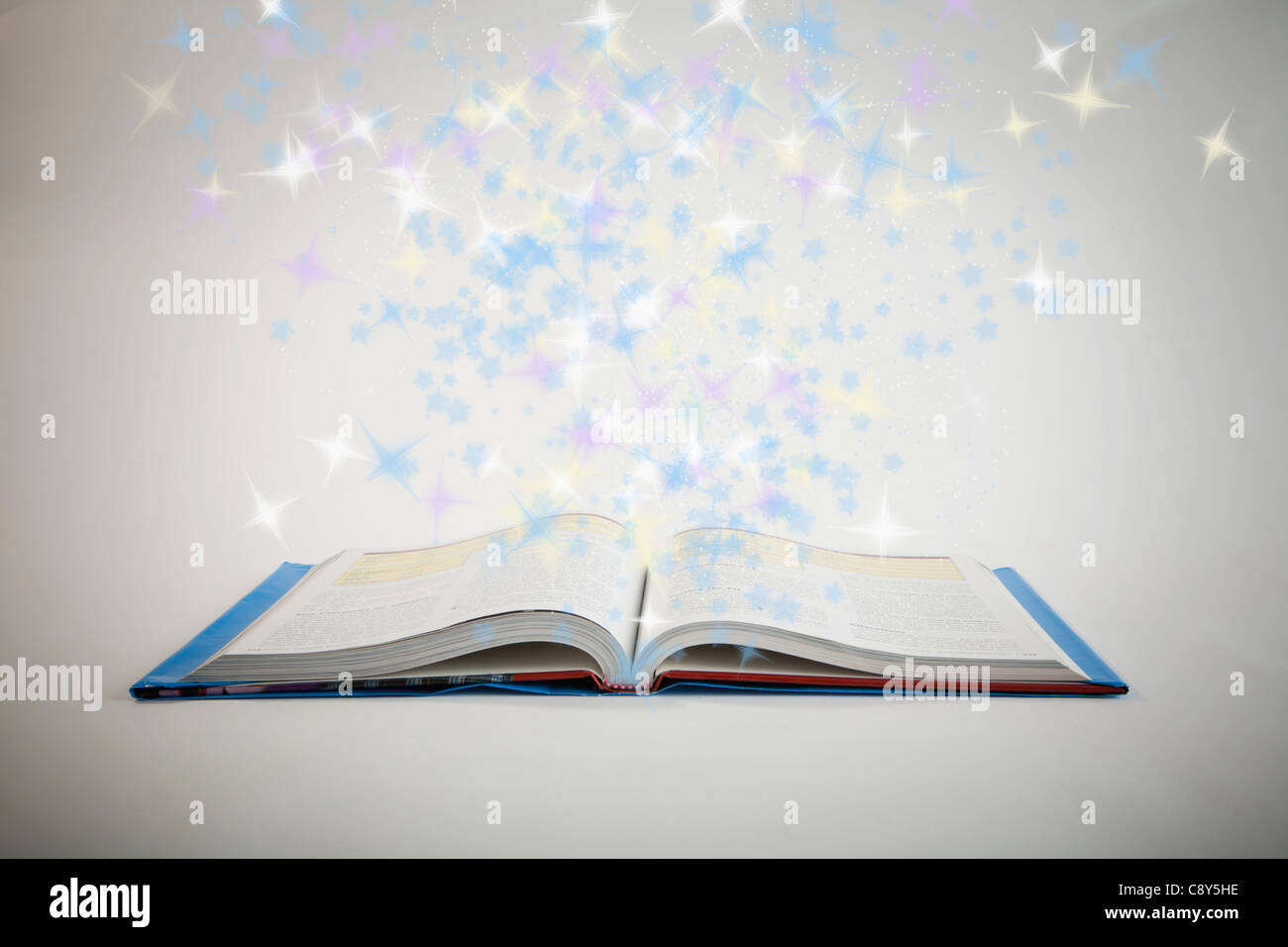 Shiny stars flying over open book Stock Photo - Alamy