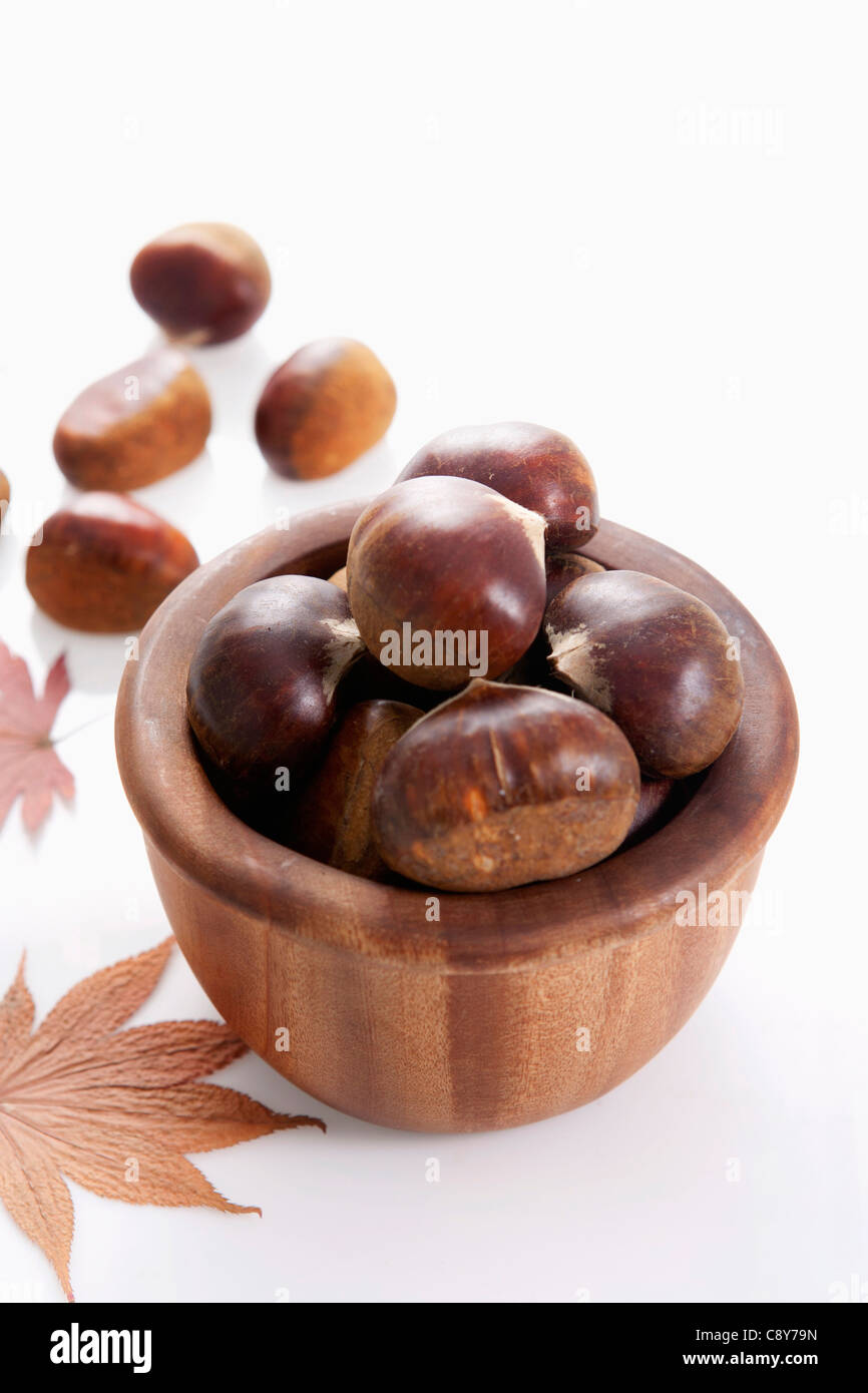 Wooden Bowl Of Chestnuts And Maple Leaves Stock Photo - Alamy