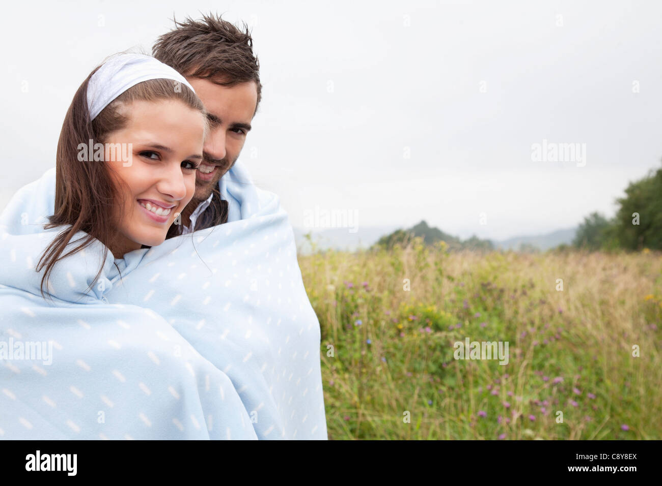 portrait of young couple outdoors wrapped in a blanket Stock Photo - Alamy