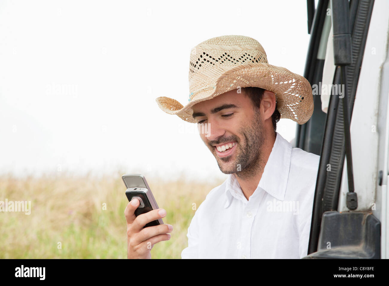 portrait of young man wearing straw hat with mobile phone Stock Photo ...