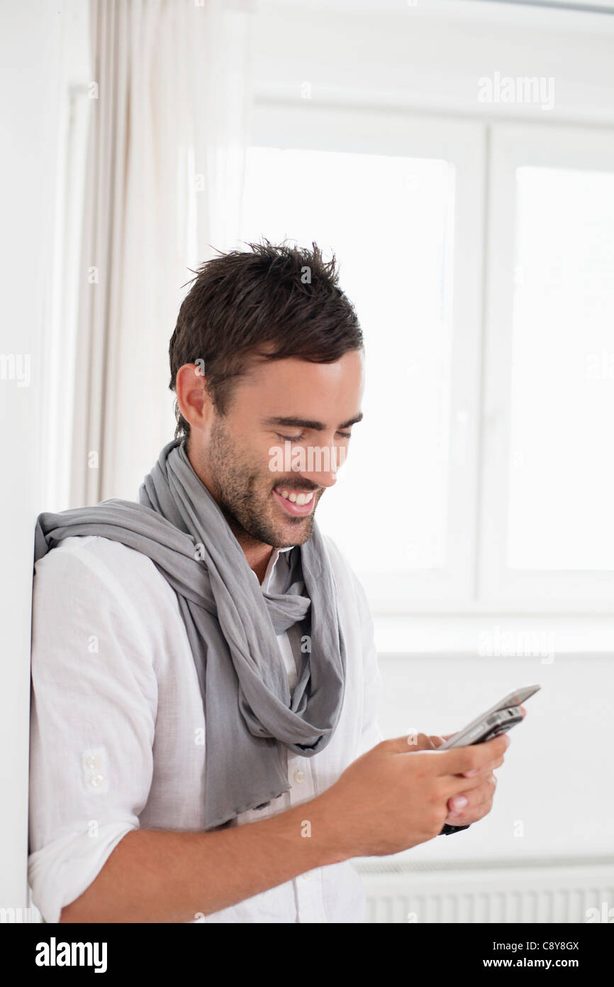 portrait of young man in empty room with mobile phone Stock Photo - Alamy
