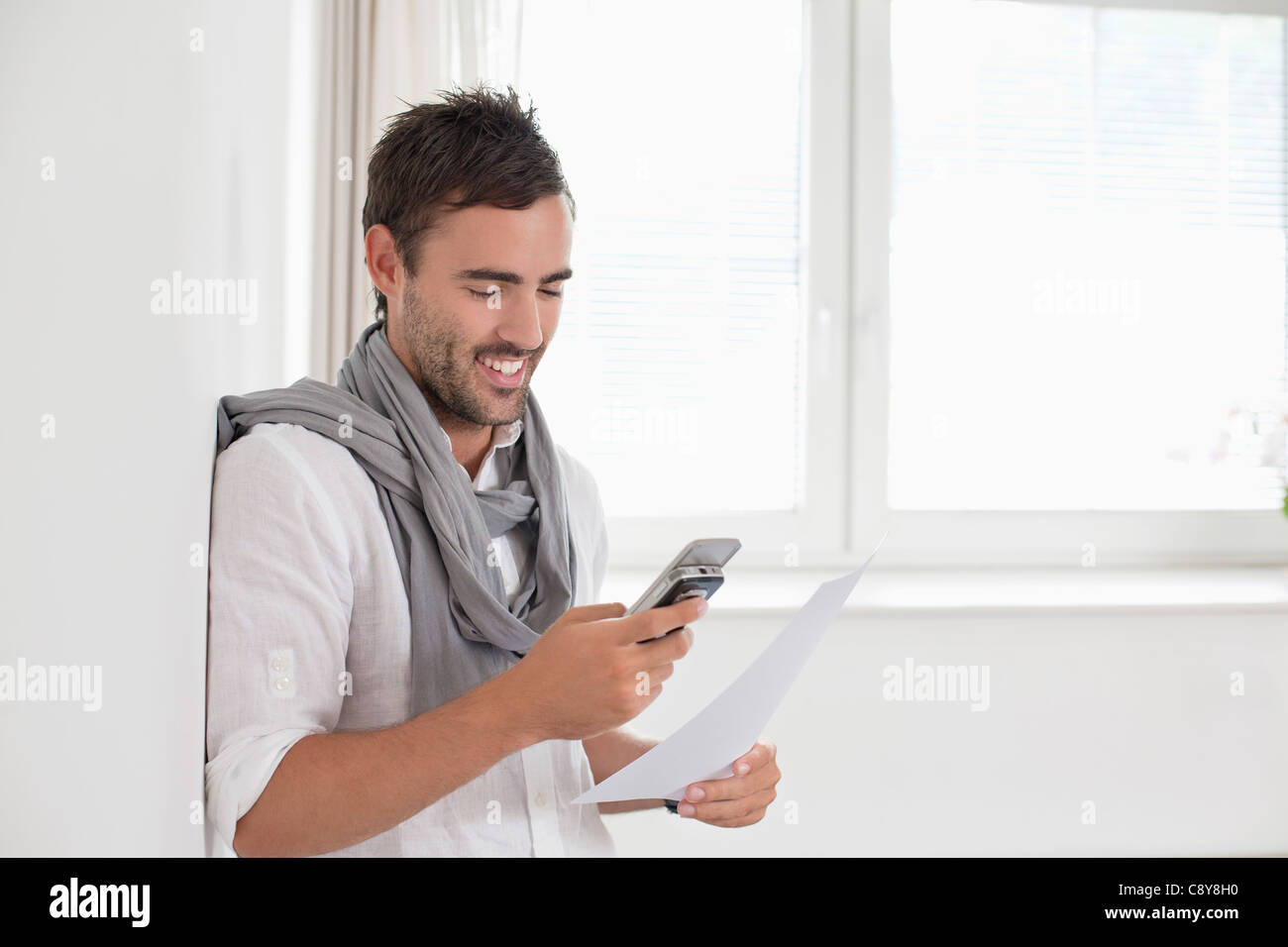 portrait of young man in empty room with mobile phone Stock Photo - Alamy