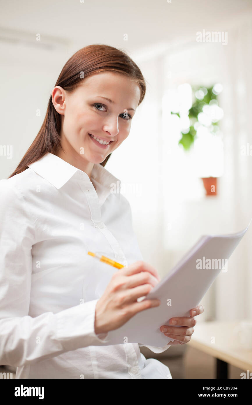 portrait of young woman at home writing document Stock Photo - Alamy