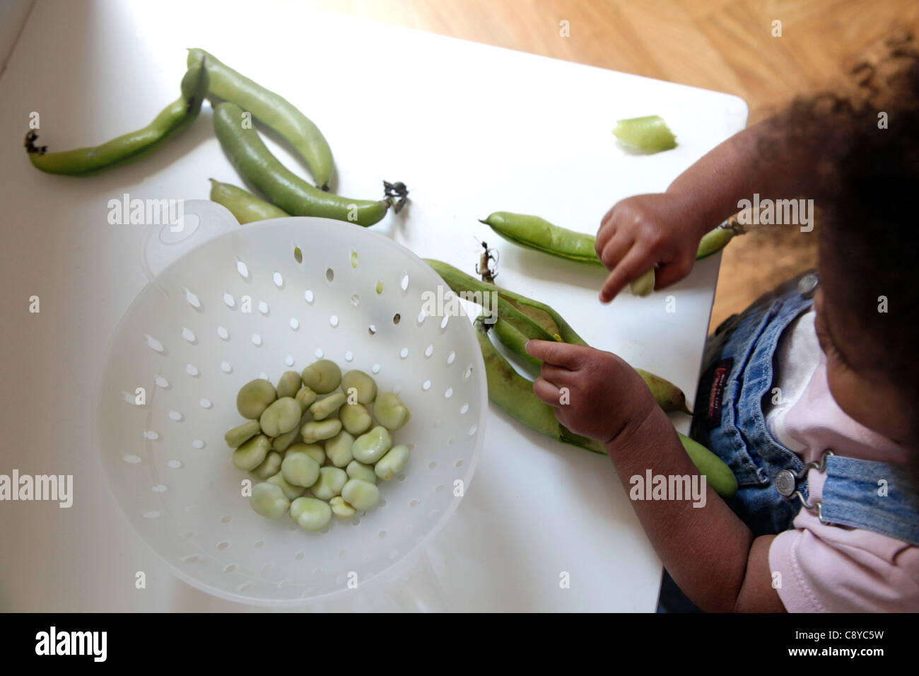 Toddler shells broad beans Stock Photo - Alamy