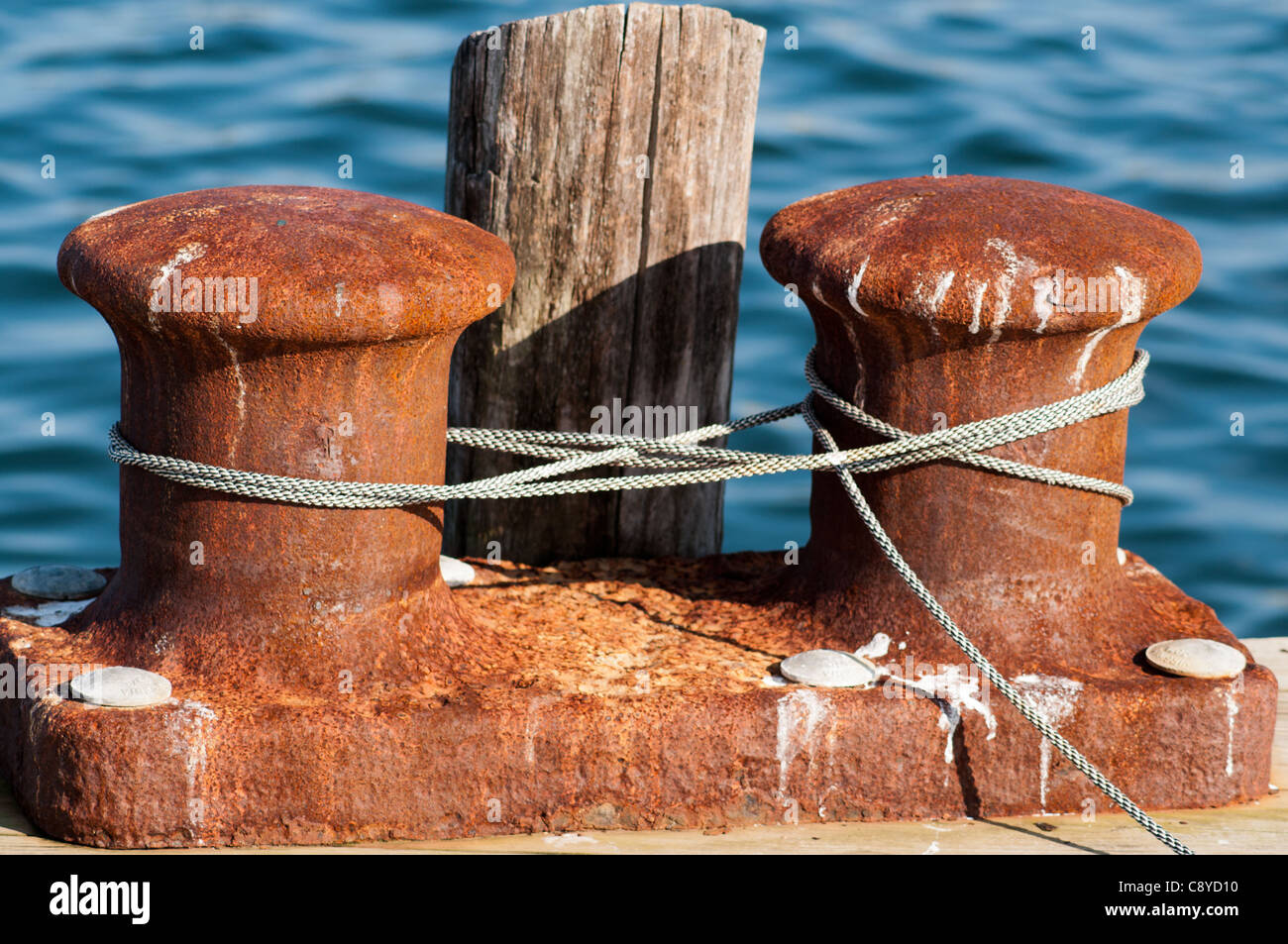 Large rusting cleat for tying up fishing vessels on an old pier in ...