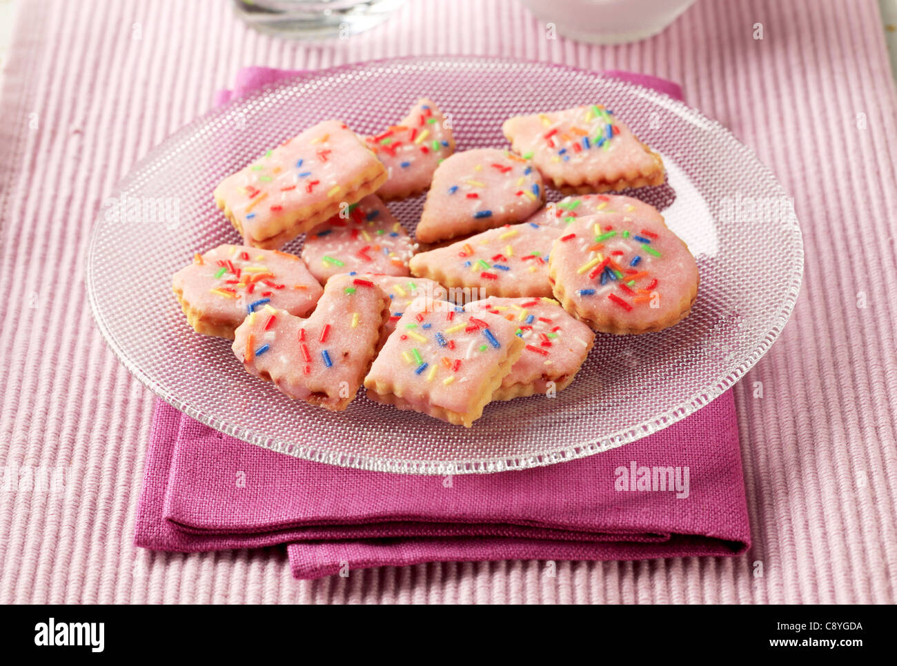 Pink frosted sugar cookies with colorful sprinkles Stock Photo - Alamy