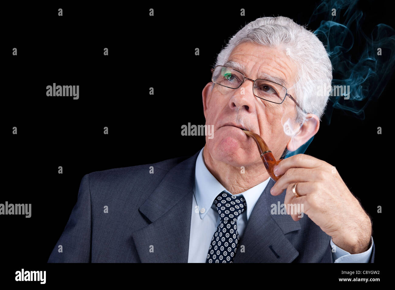 Senior businessman thinking while smoking his pipe (isolated on black ...