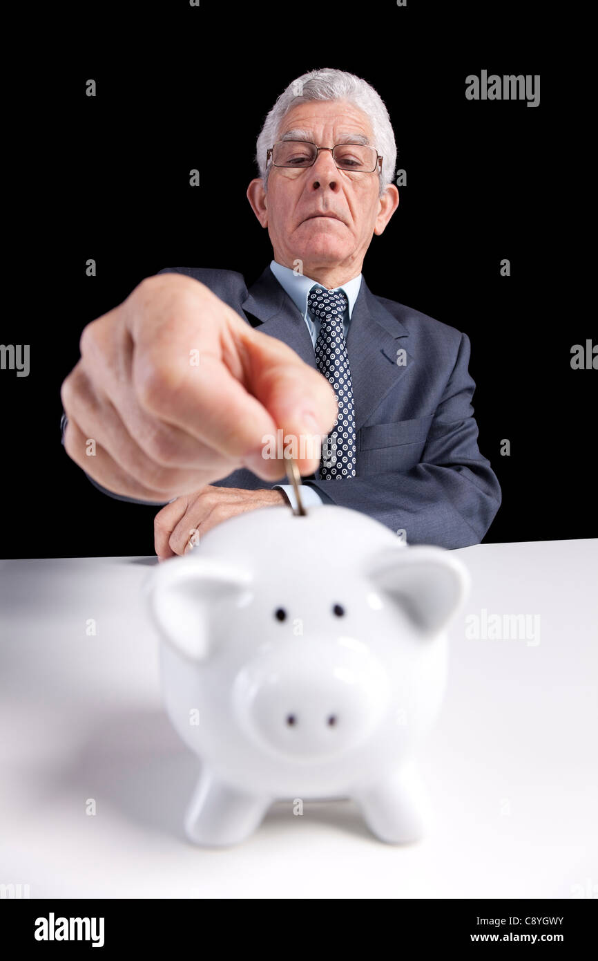 Senior businessman saving some money for his retirement (isolated on ...
