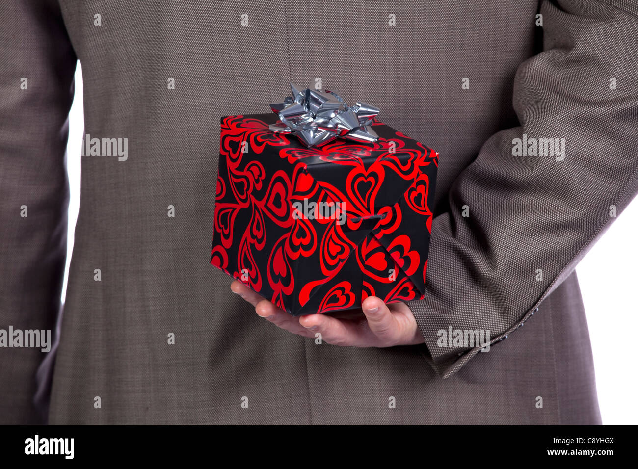 Businessman holding a wrapped Valentine present behind his back Stock ...