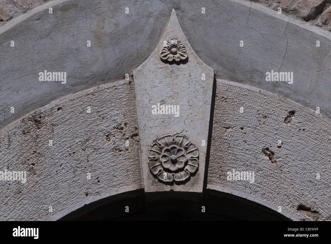 A close-up view of a decorative keystone, with symbols carved in the ...