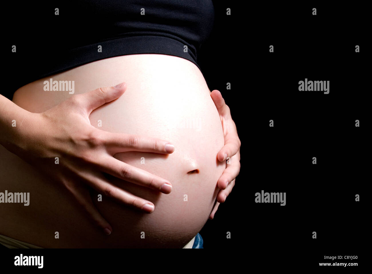 A pregnant lady holds her belly Stock Photo - Alamy