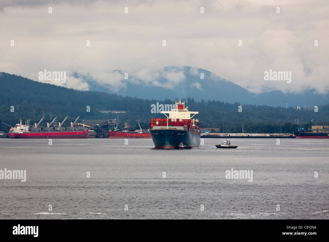 A tug pushes a freighter out in English Bay or Vancouver Harbor in ...