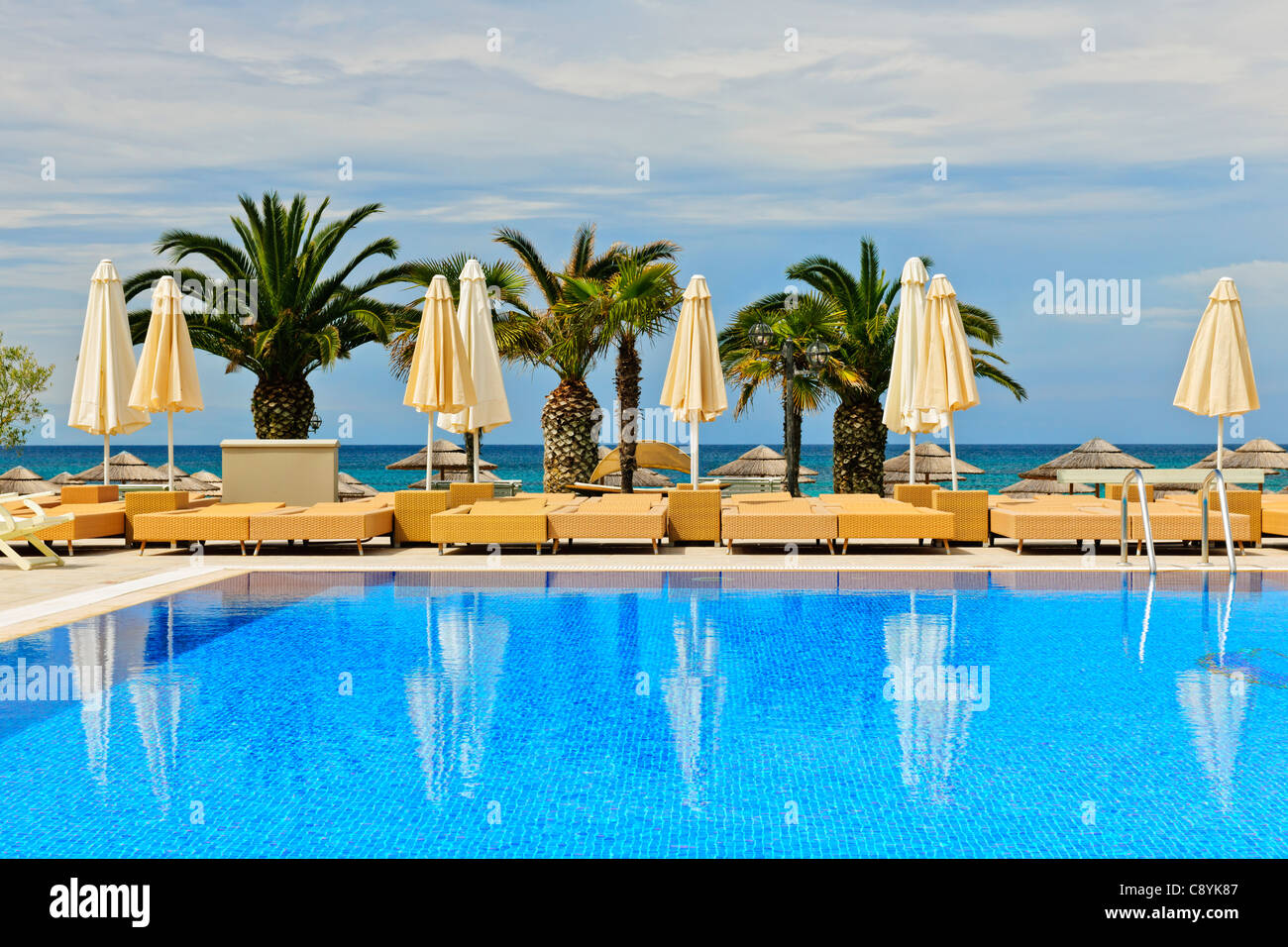 Idyllic swimming pool at tropical resort with palm trees in Greece ...