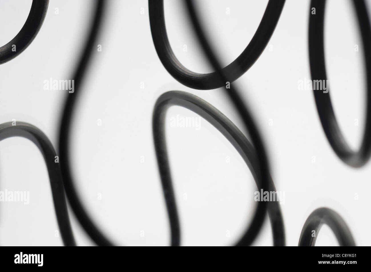 A close-up image of a grey metal wire twisted in rounded shpapes ...