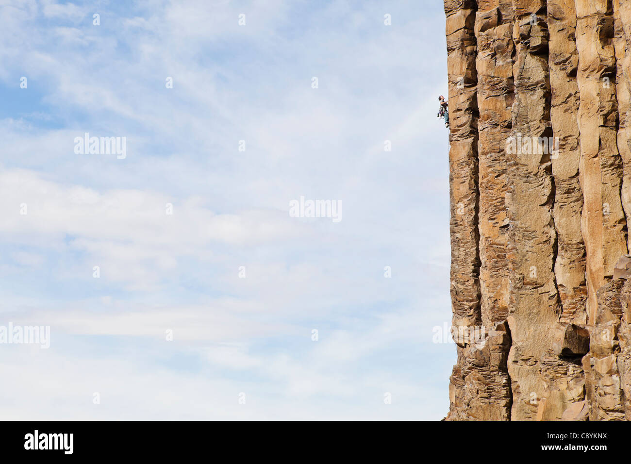 A man climbing a basalt rock cliff in central Washington State, USA ...