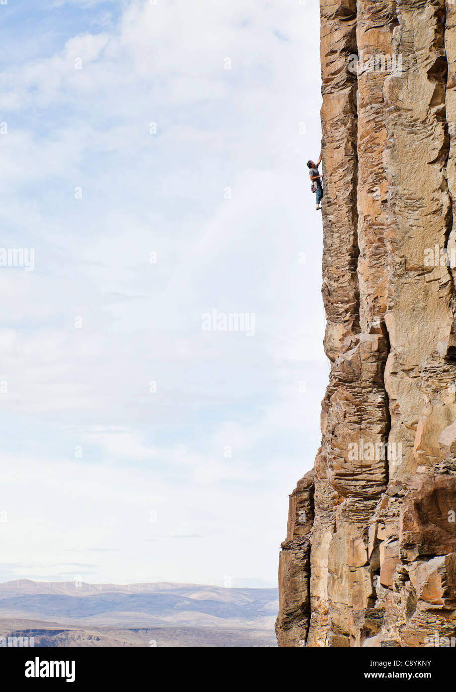 A man climbing a basalt rock cliff in central Washington State, USA ...