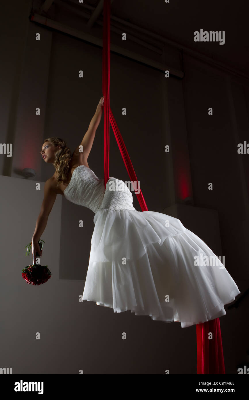 Female model aerial silks acrobat posing in a wedding dress in the air ...