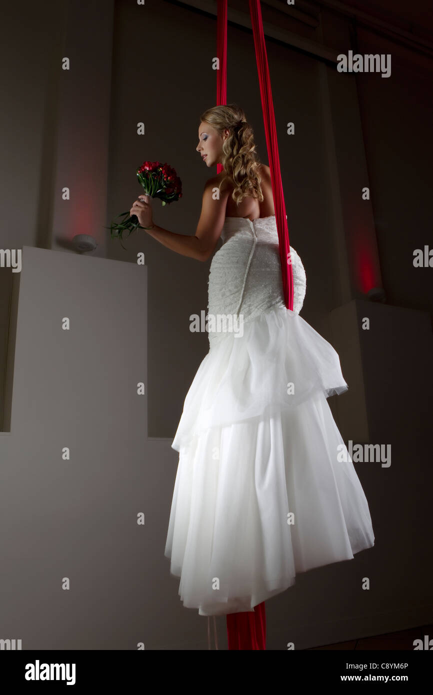 Female model aerial silks acrobat posing in a wedding dress in the air ...