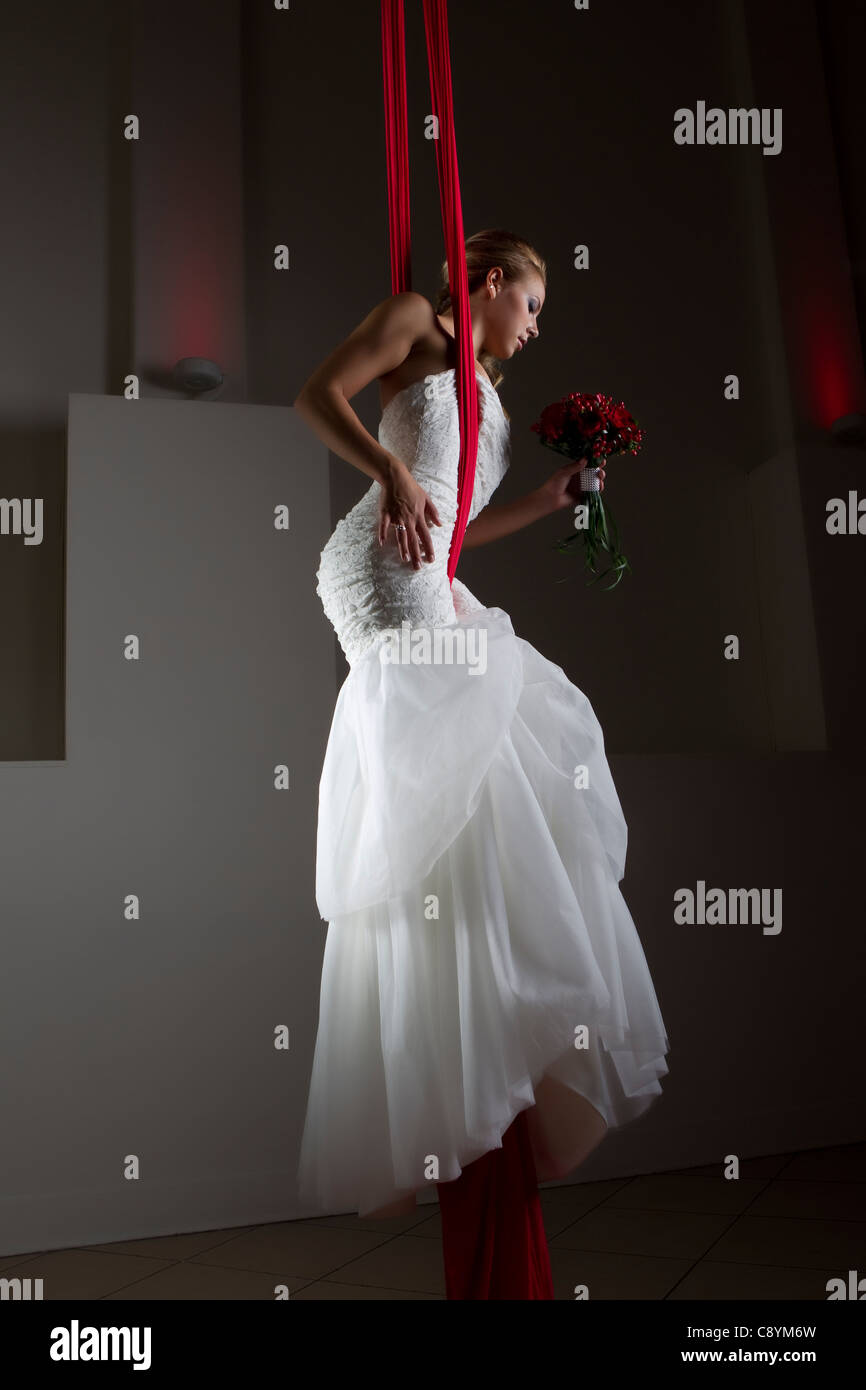 Female model aerial silks acrobat posing in a wedding dress in the air ...
