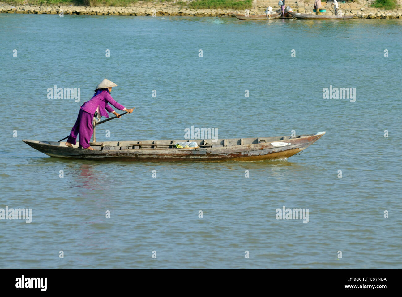 Asia, Vietnam, Hoi An. Vietnamese woman rowing her boat across the Thu ...