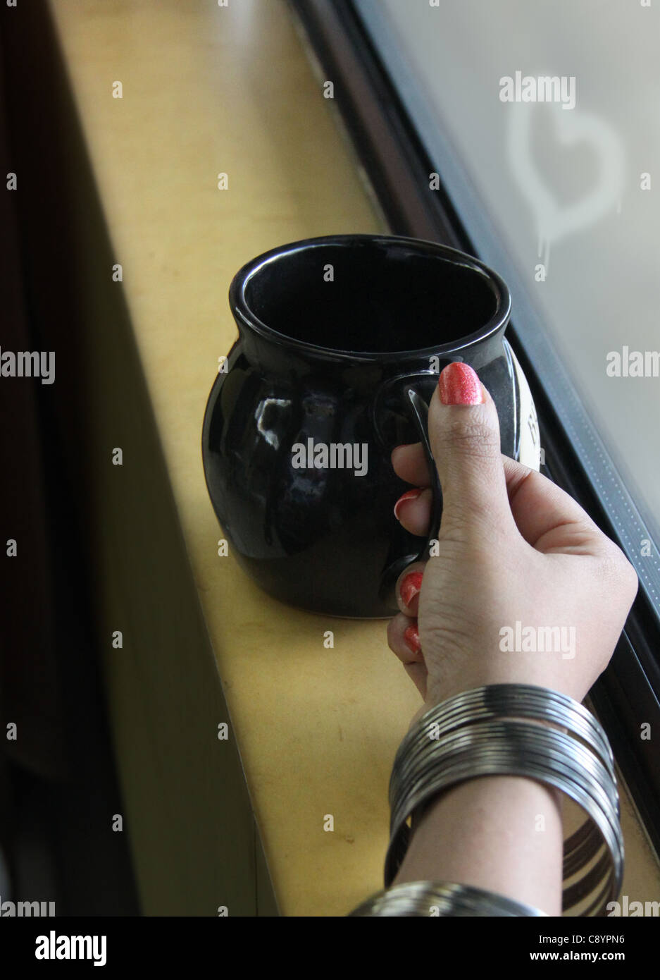 Woman wearing bangles and drinking coffee Stock Photo - Alamy