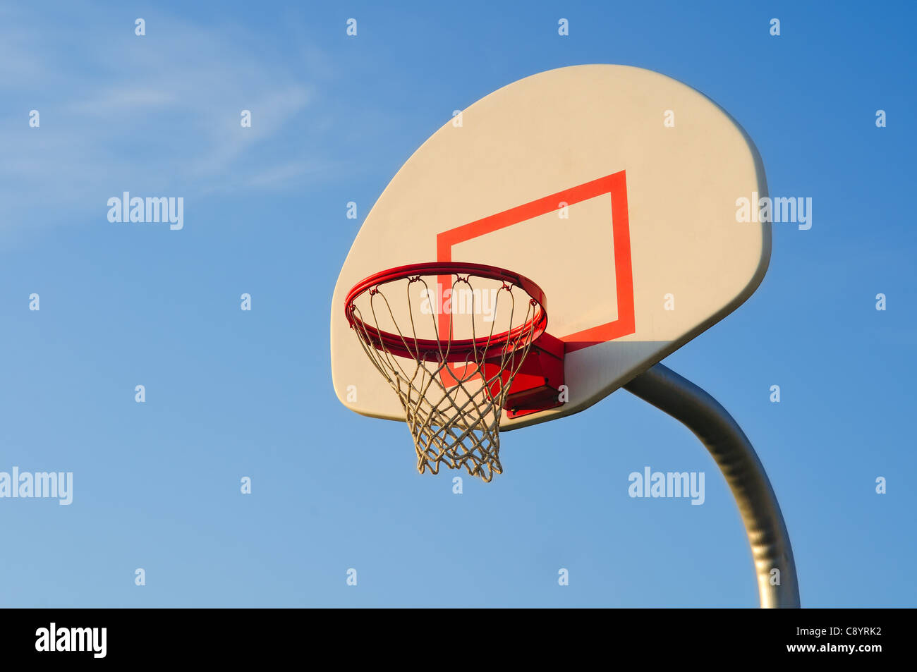 A basketball hoop and backboard against a bright blue sky Stock Photo ...