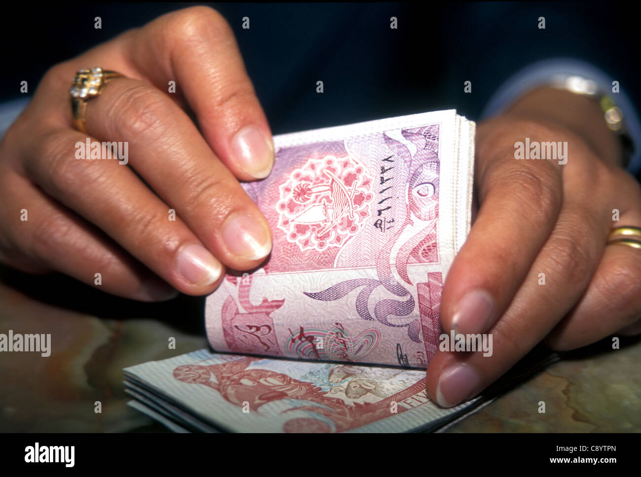 Hands of a cashier counting Qatari riyal notes, 1995 Stock Photo - Alamy