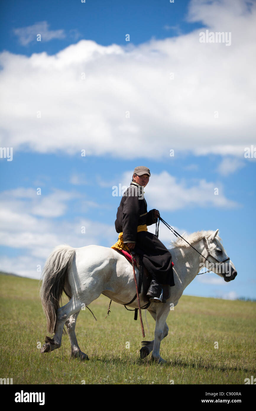 Mongolian boy riding horse at green steppe at Naadam festival ...