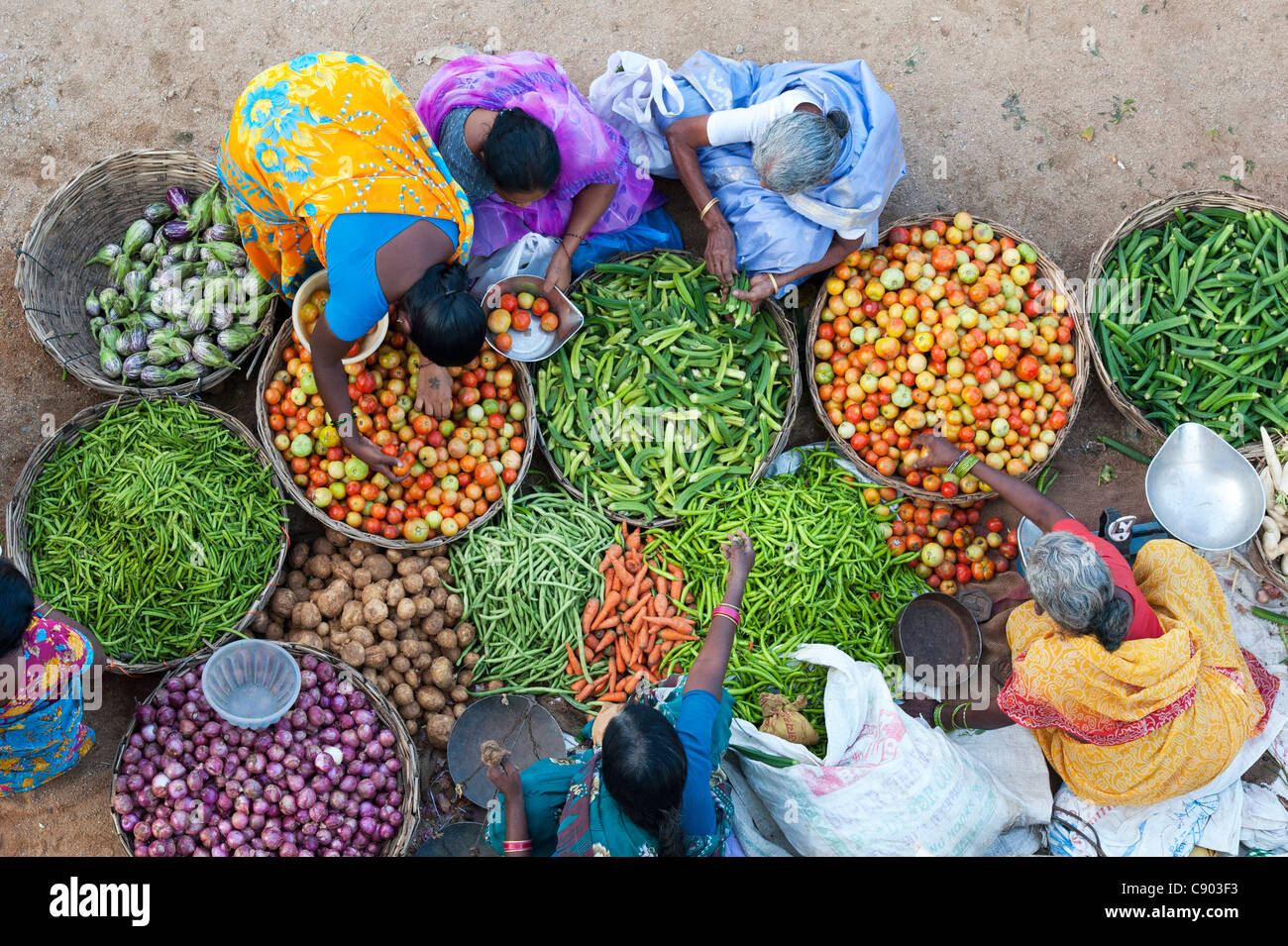 Indian women buy vegetables from a street market in Puttaparthi, Andhra ...