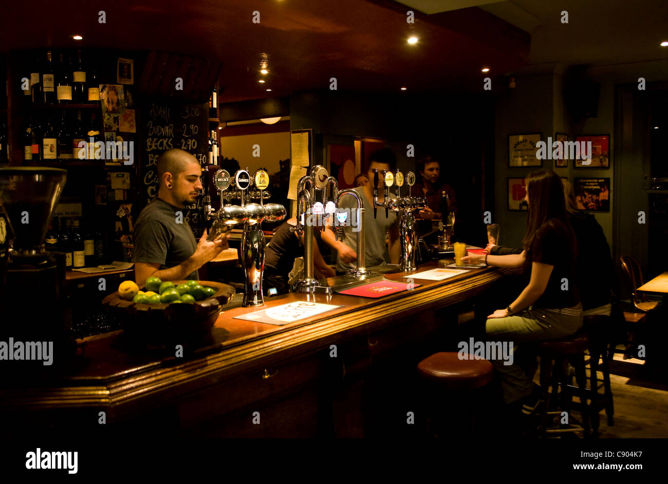 A guy behind the bar is pouring beer into glass in a pub Stock Photo ...