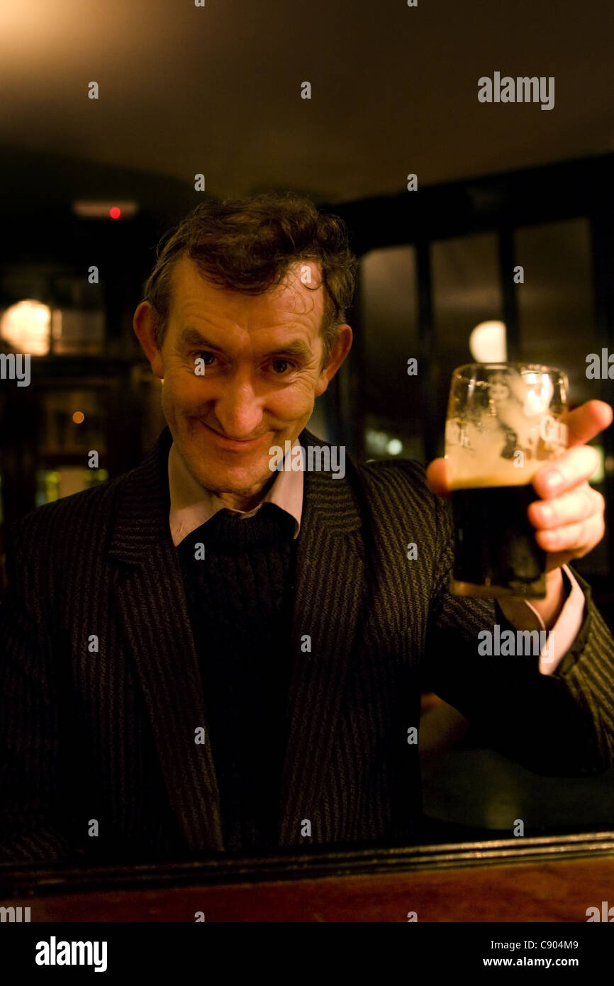 Old man is holding glass of Guinness beer and smiling Stock Photo - Alamy